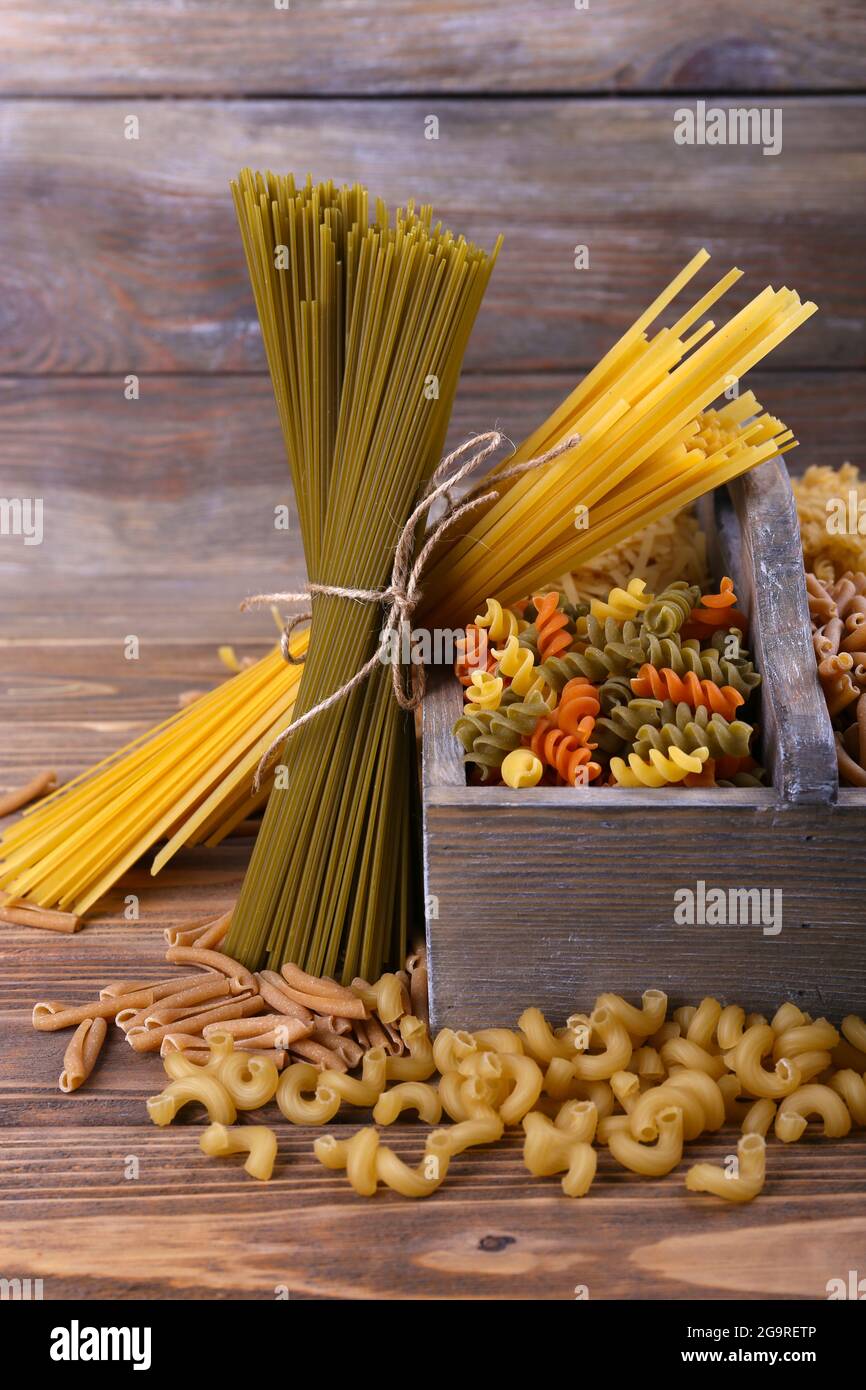Different types of pasta in box on wooden background Stock Photo - Alamy