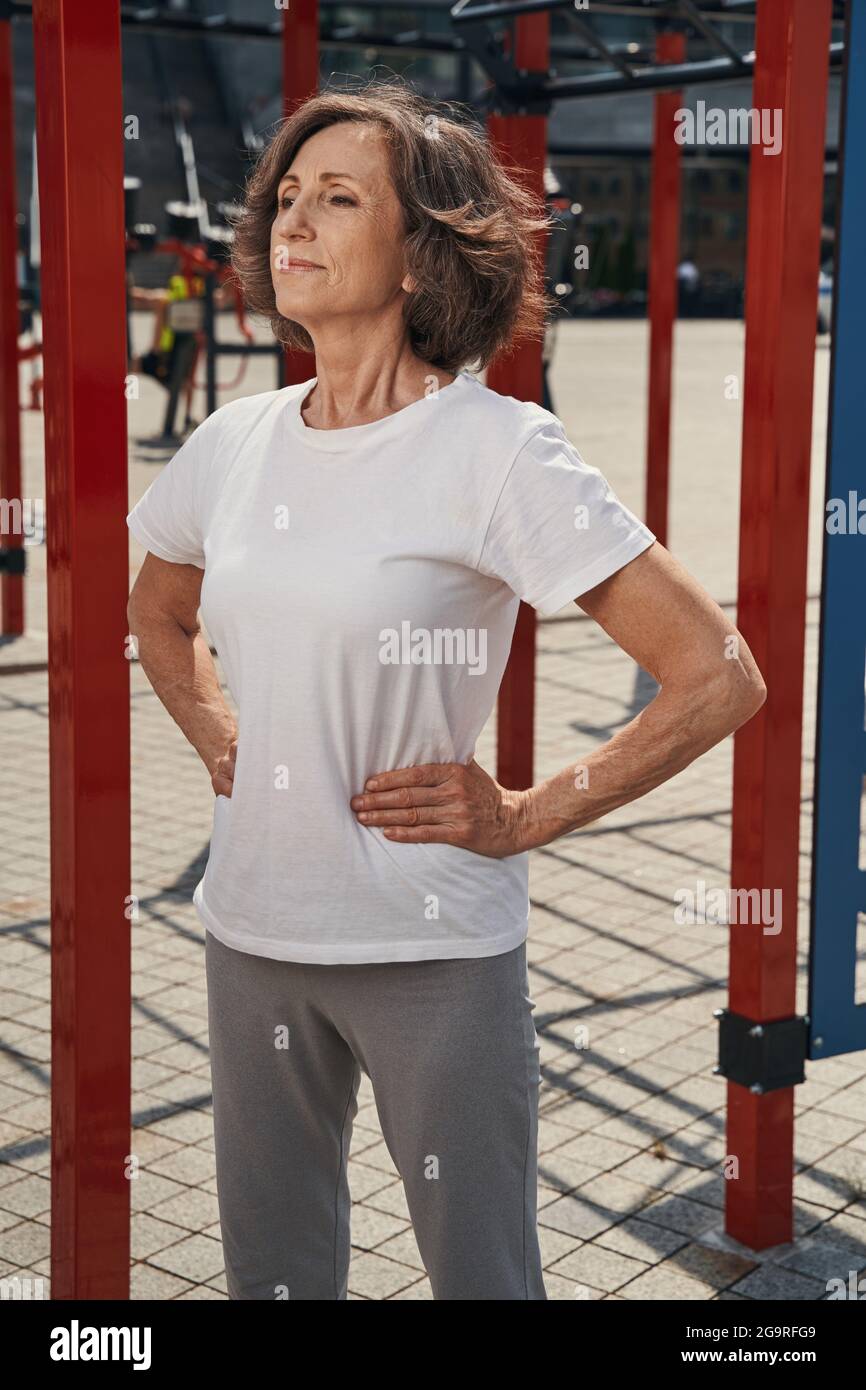 Active mature woman exercising on sports ground Stock Photo - Alamy