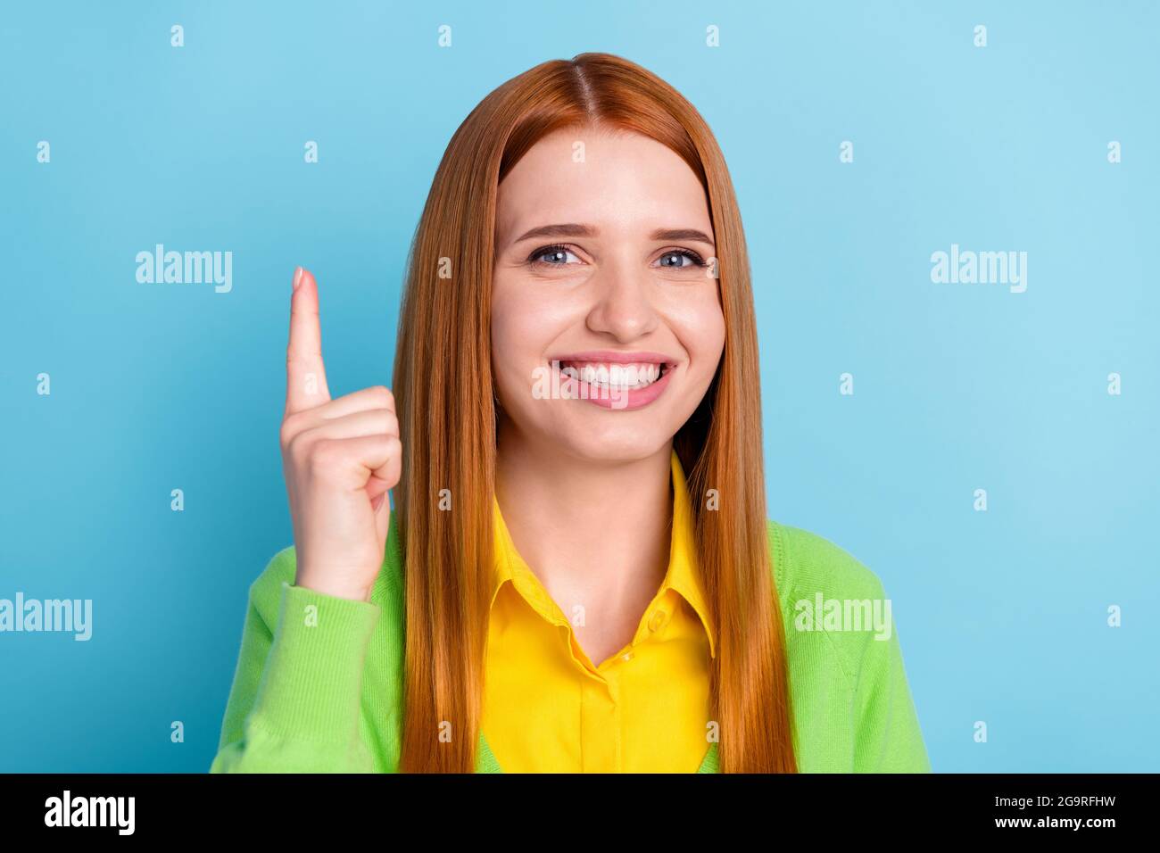 Photo of smart young lady point up wear yellow sweater isolated on blue ...