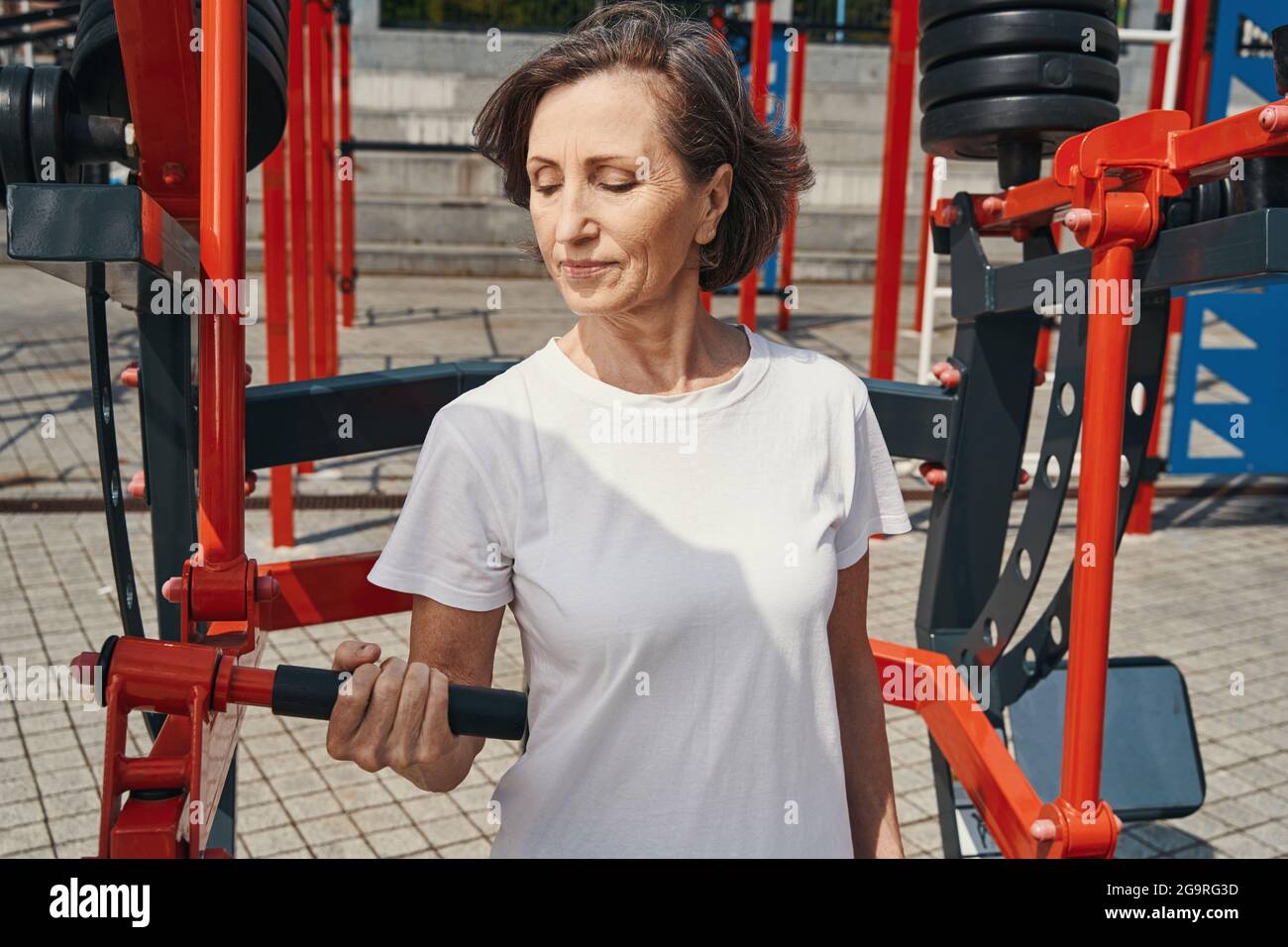 Active mature lady training with sport machine outdoors Stock Photo - Alamy