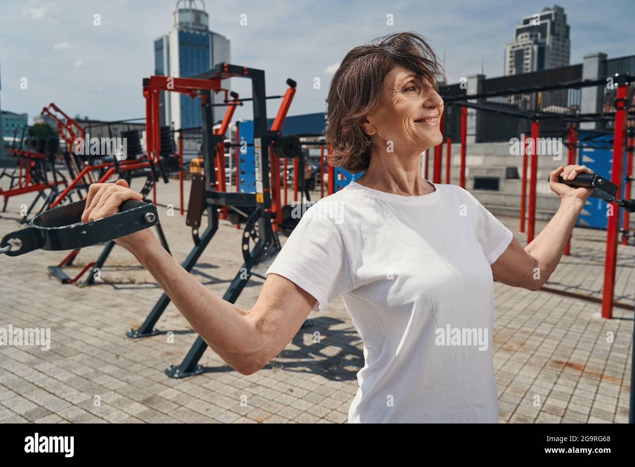 Happy mature female enjoying workout on sports ground Stock Photo - Alamy