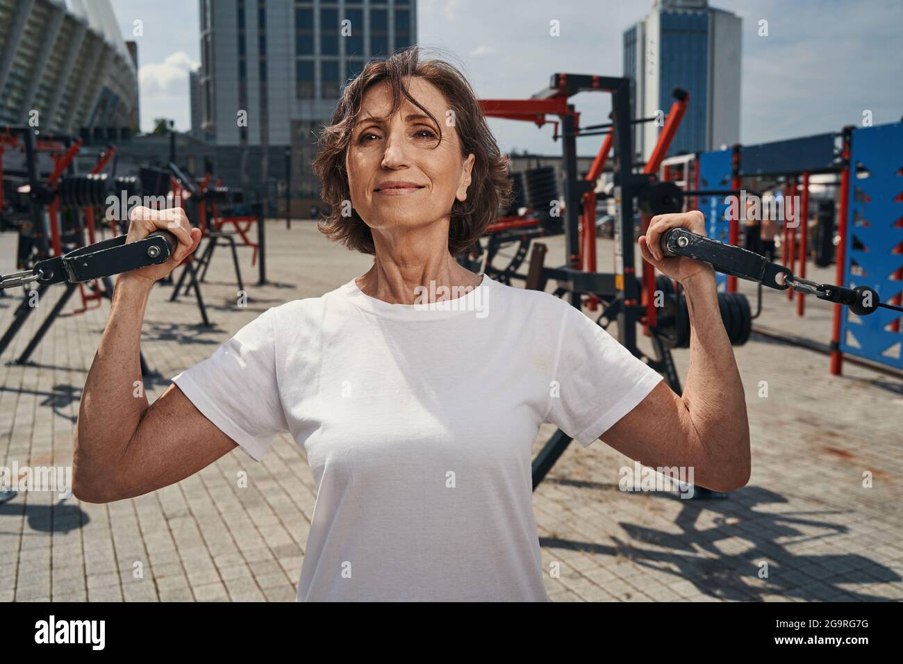 Happy active lady exercising upper body outdoors Stock Photo - Alamy