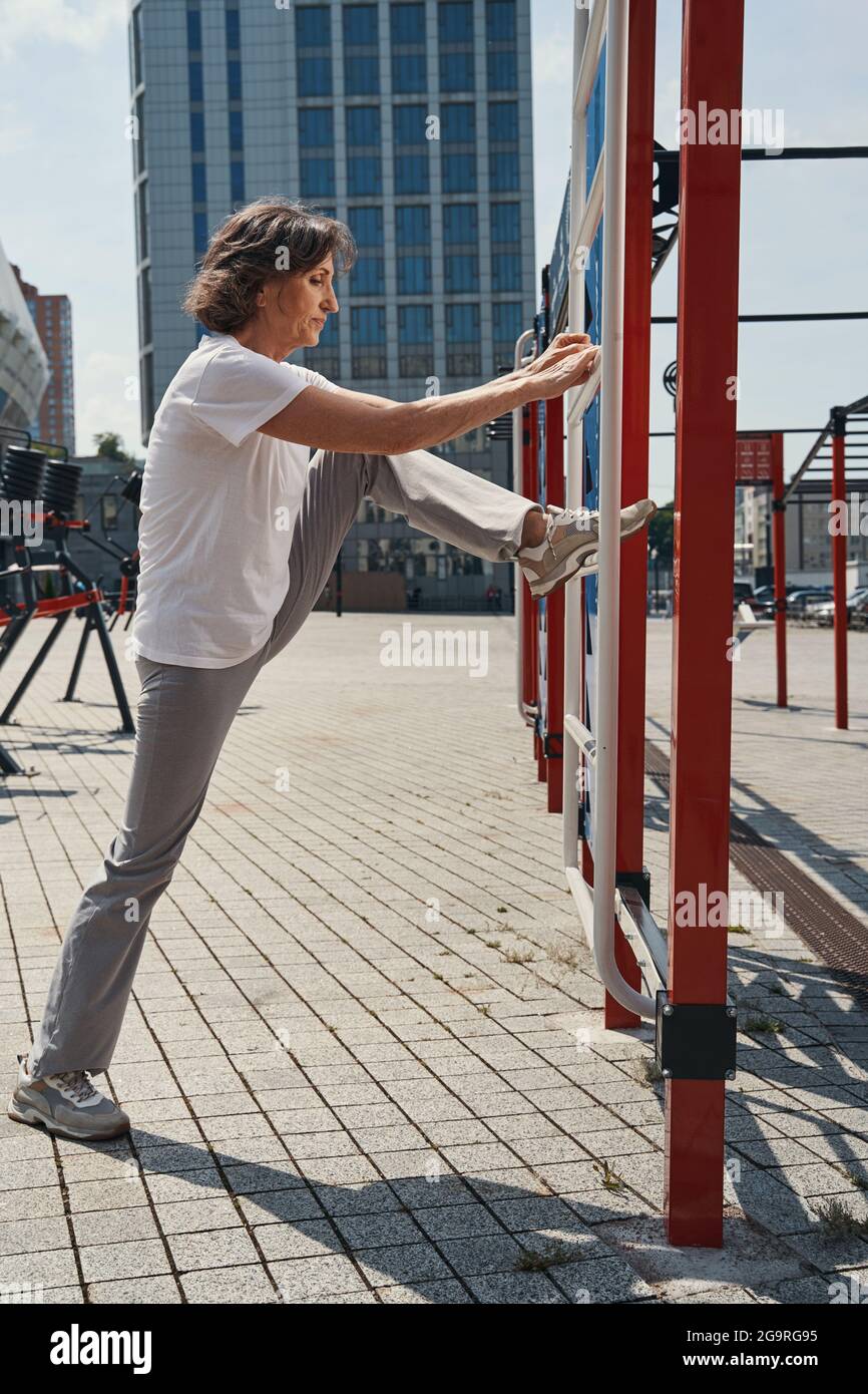 Fit mature woman doing flexibility exercises outdoors Stock Photo - Alamy