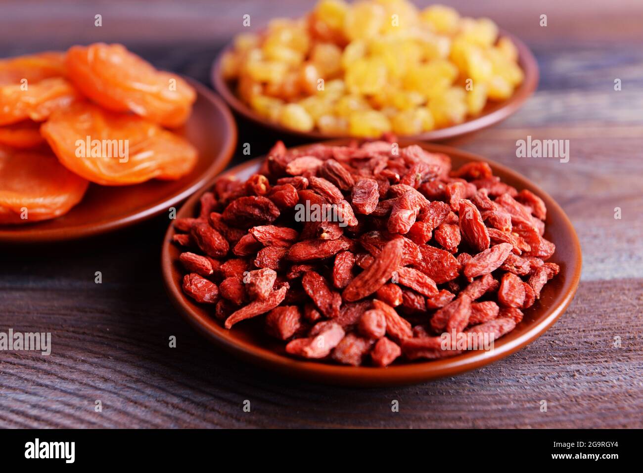 Dried fruits in small plates on rustic wooden table background Stock ...