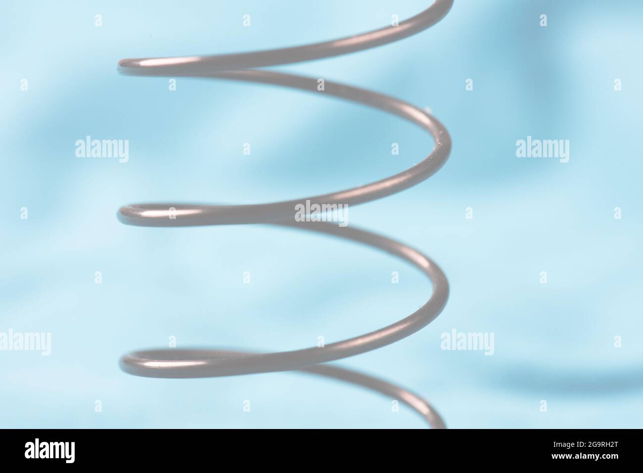 Details of a metal spring on blue cloth Stock Photo - Alamy