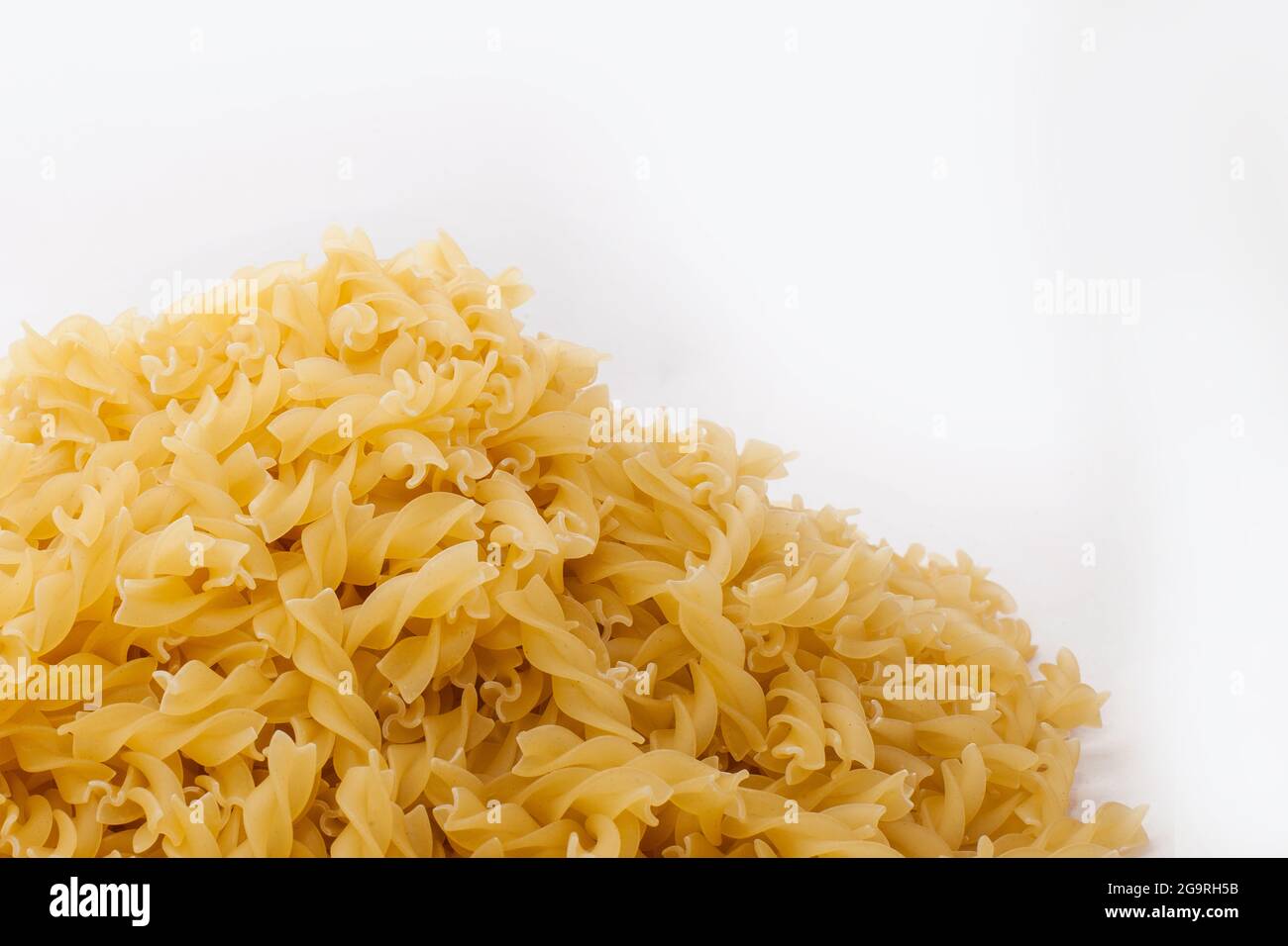 Italian spiral pasta texture with selective focus, white studio ...