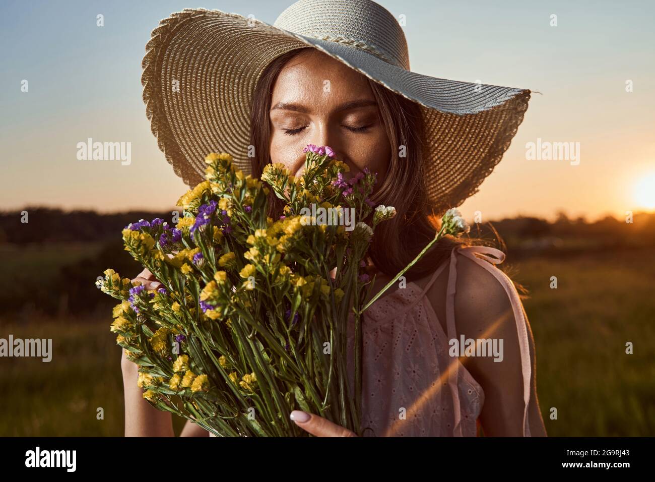 Pleased woman adoring the odour of flowers Stock Photo - Alamy