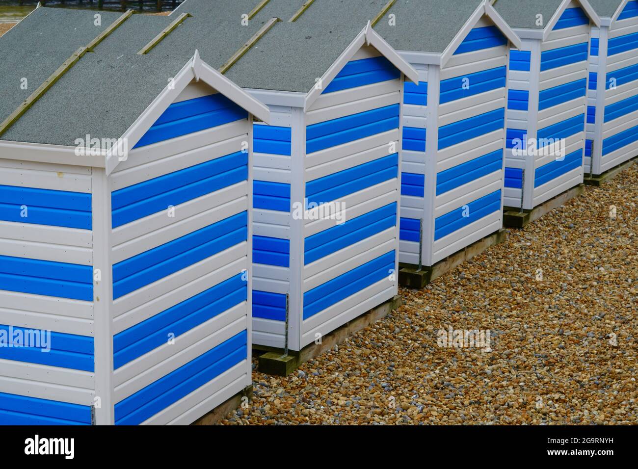 Beach huts on Hastings beach. Thes brightly coloured blue and white ...