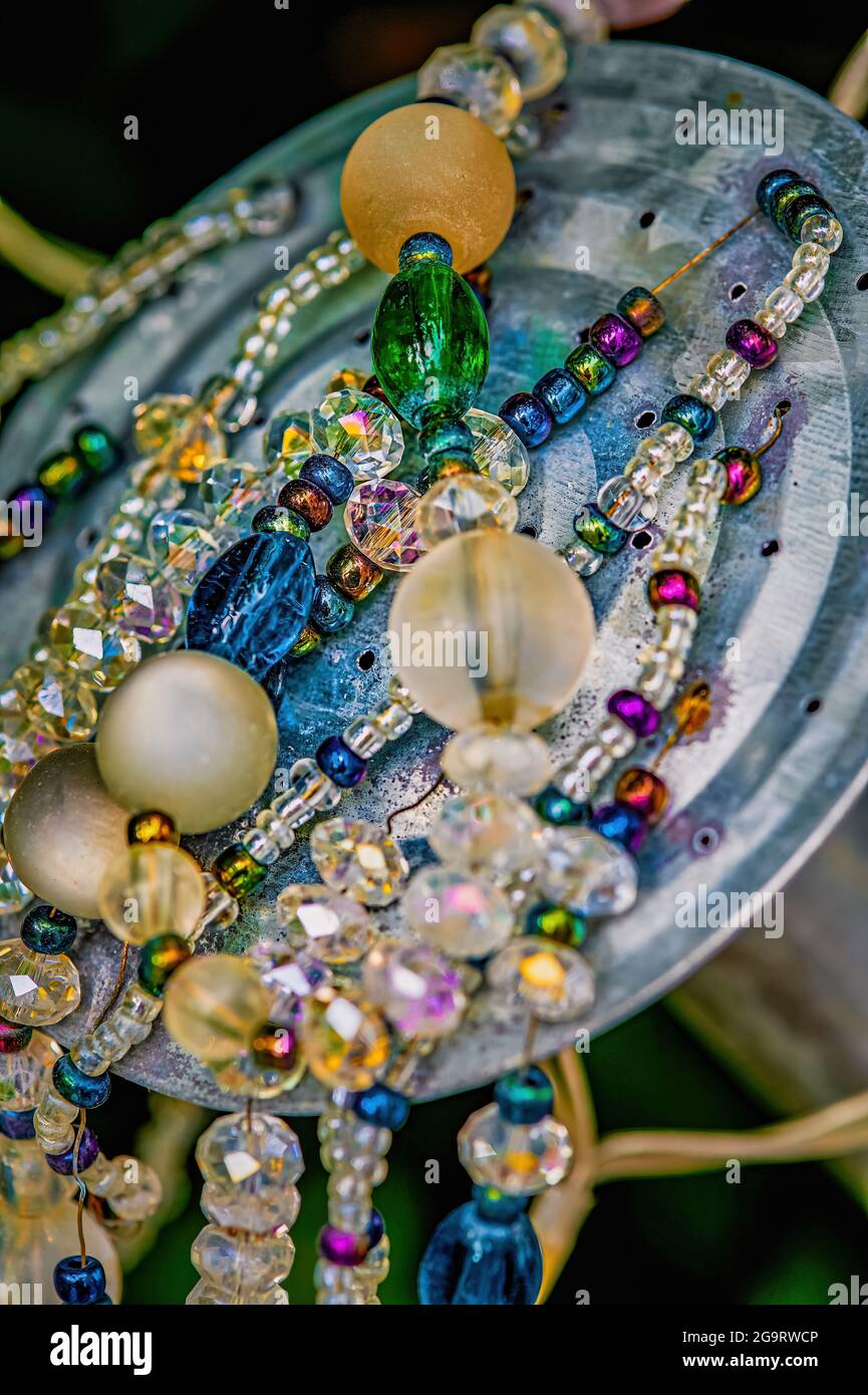 Colorful glass beads on strings that hang decoratively over the spout ...