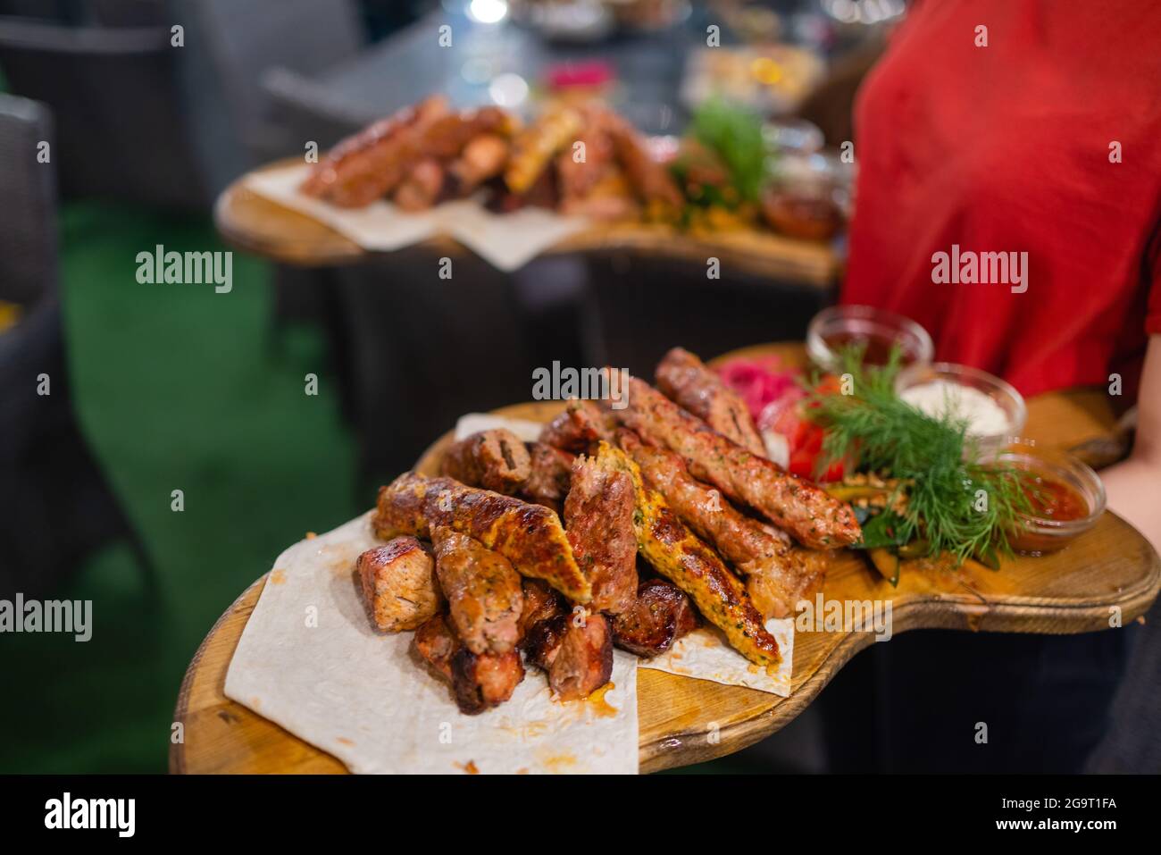 Waiter carrying two plates with meat dish on some festive event, party ...