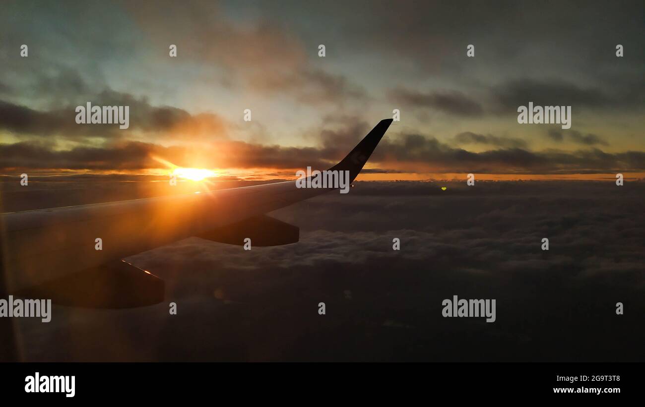 view of clouds and sun beam through the window of the plane. High ...