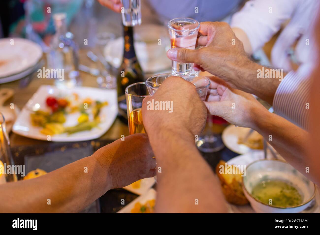Clinking glasses with alcohol and toasting, party Stock Photo - Alamy