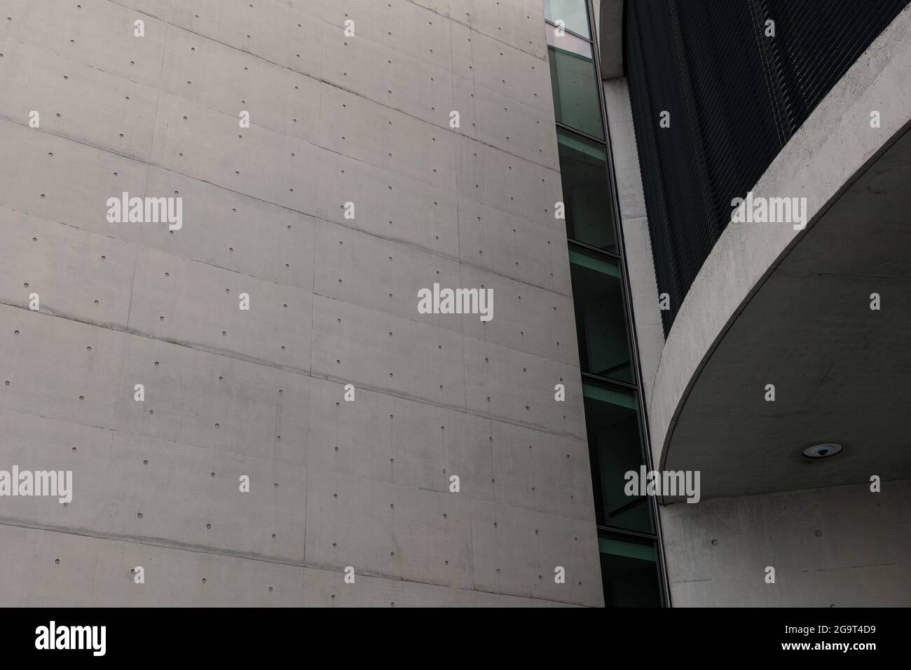 Close-up detail of exterior concrete wall, floor, vertical window with ...