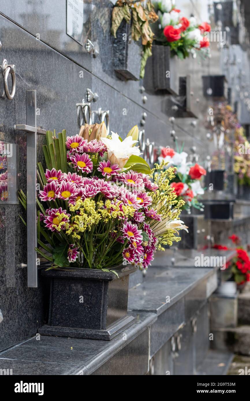 Vertical shallow focus shot of bouquets below dark marble tombstones at ...