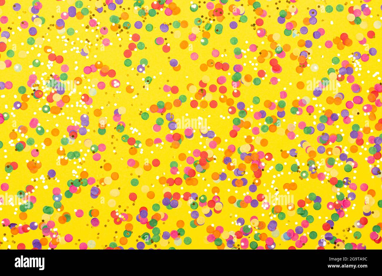 Scattered confetti on yellow background. Holiday decoration concept ...
