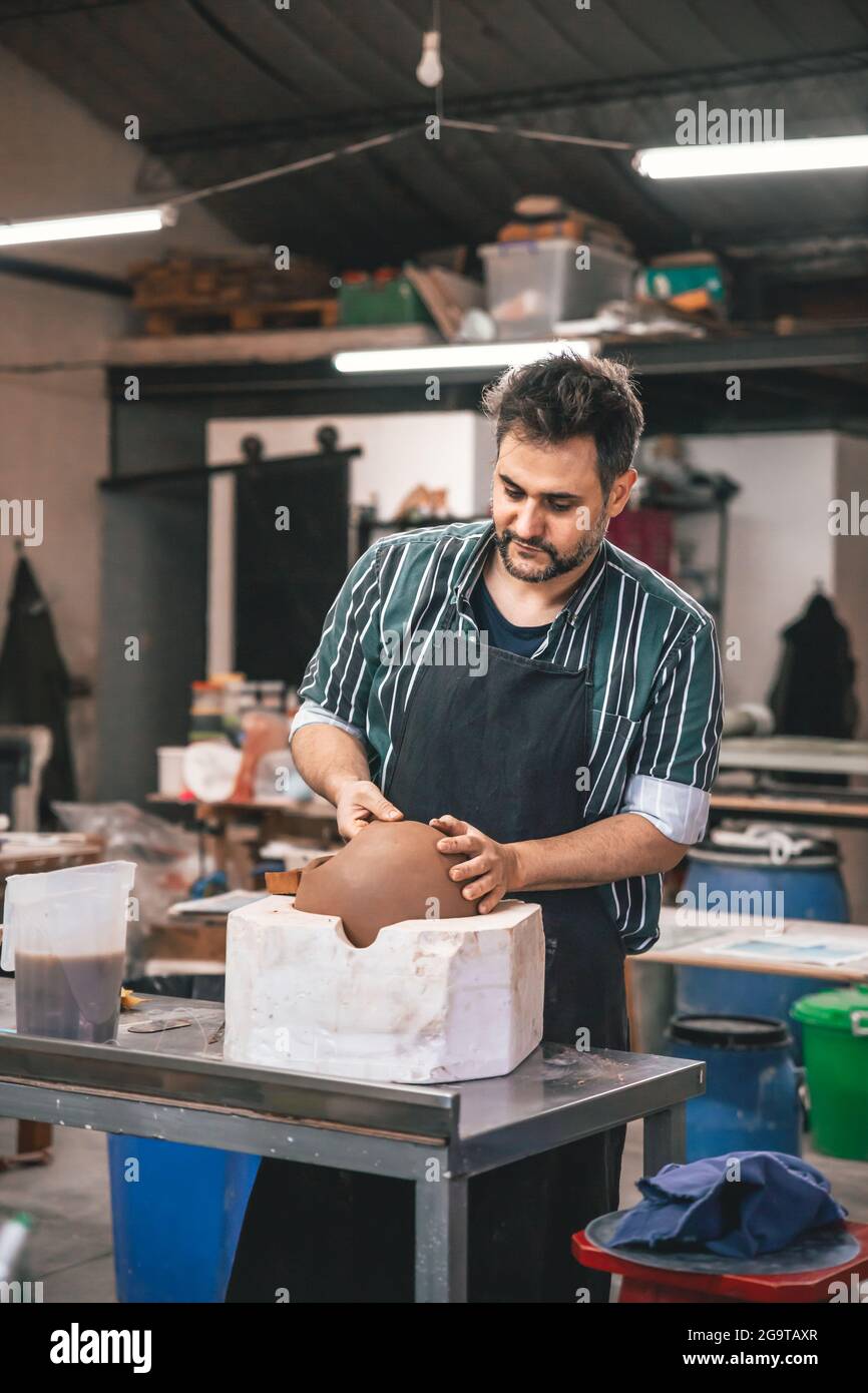 Adult Hispanic man making a clay pot on a table in a workshop Stock ...
