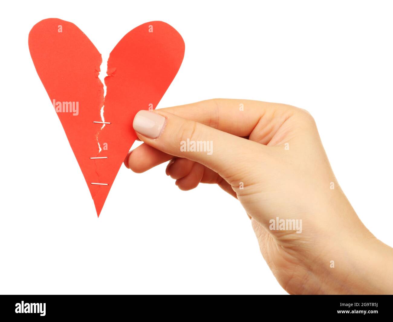 Female hand holding broken heart stitched with staples isolated on ...
