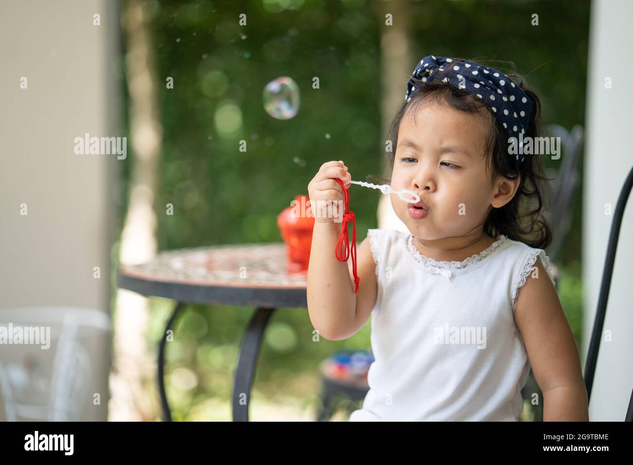Cute Asian female child blowing bubbles Stock Photo - Alamy
