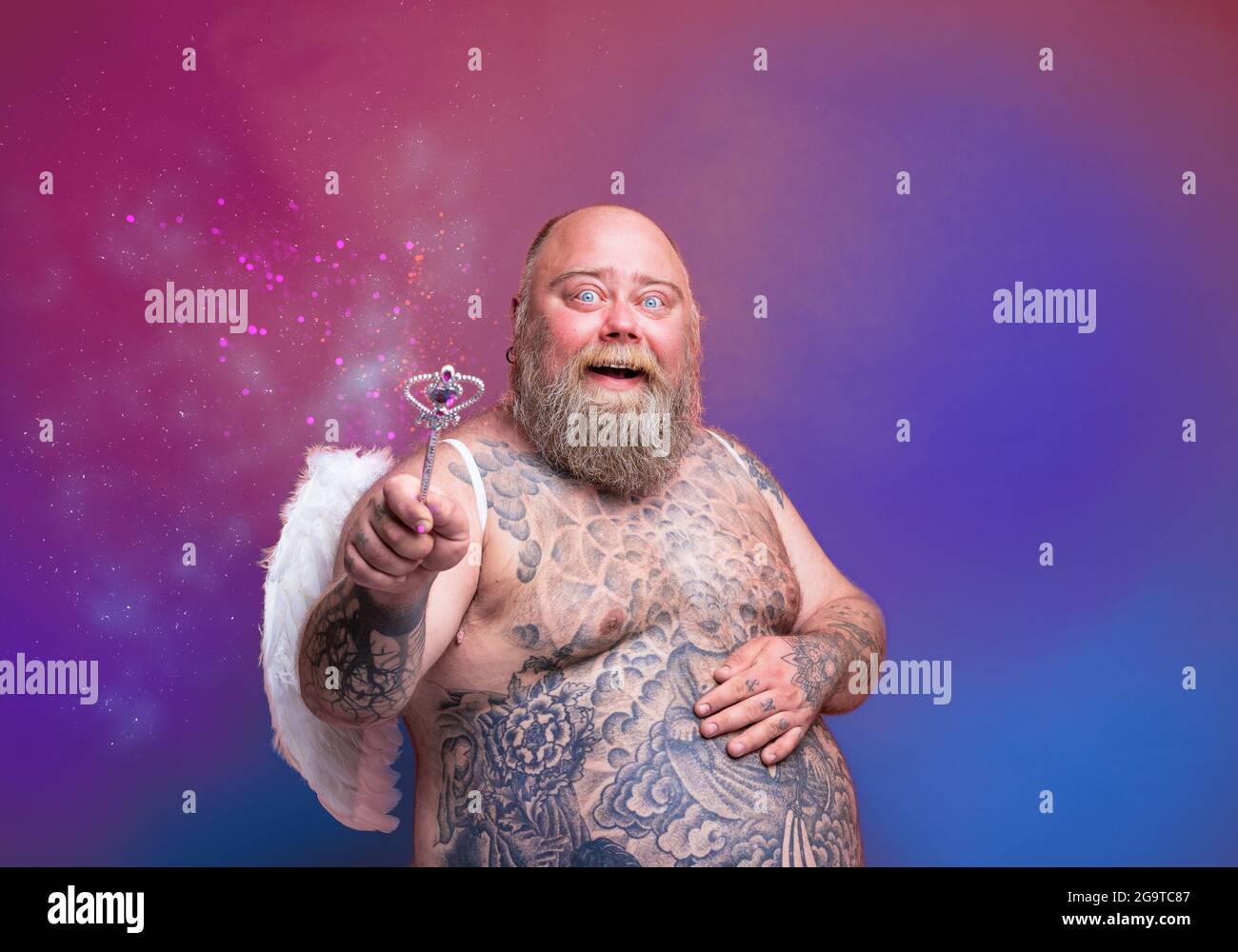 Fat happy man with beard ,tattoos and wings acts like an magic fairy ...