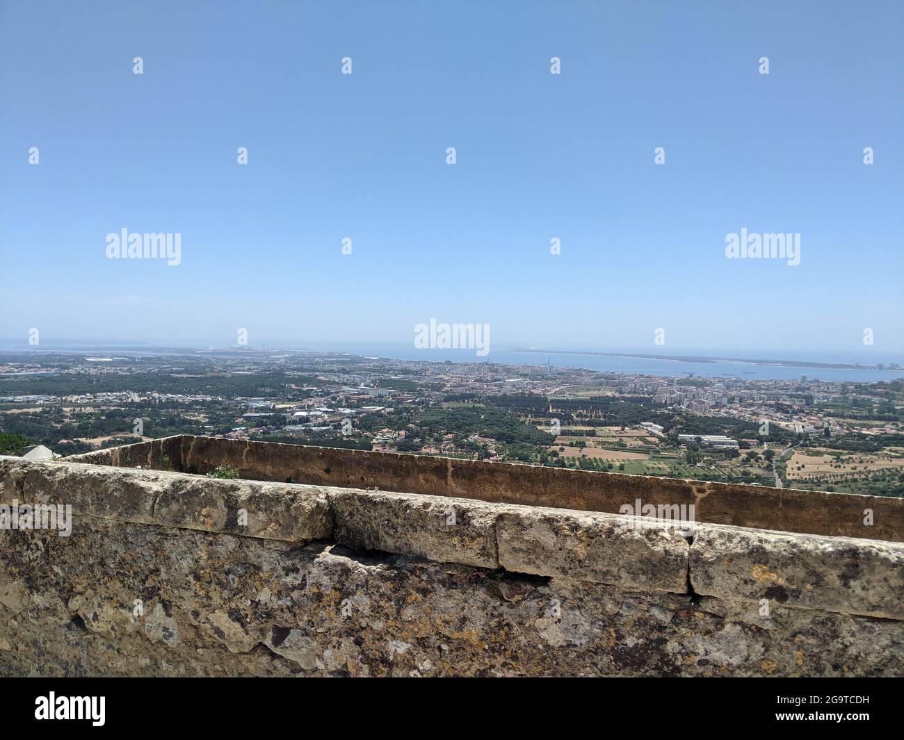 View of a beautiful town covered with vegetation seen from a stone ...