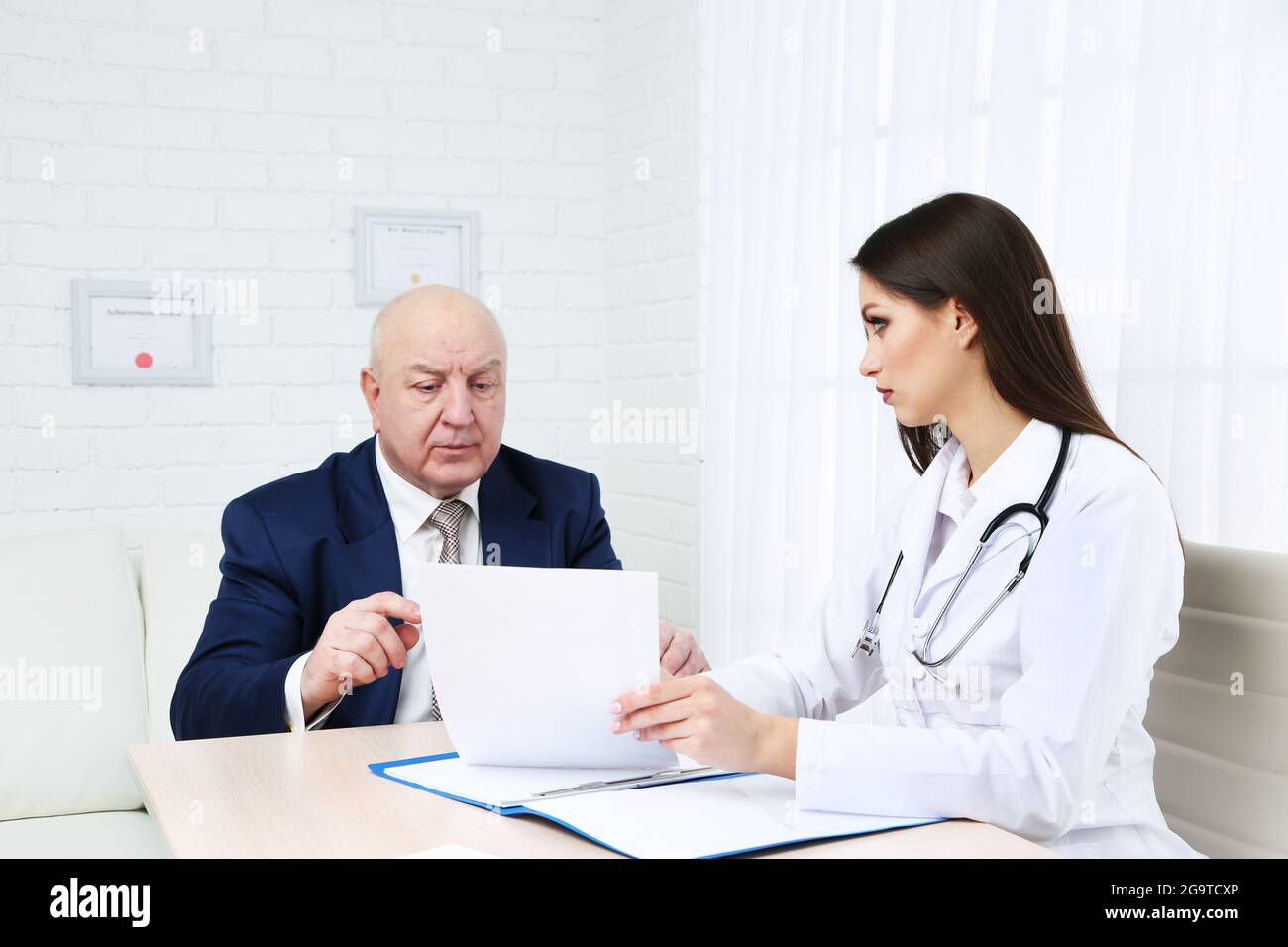 Young female doctor receiving patient in her office Stock Photo - Alamy