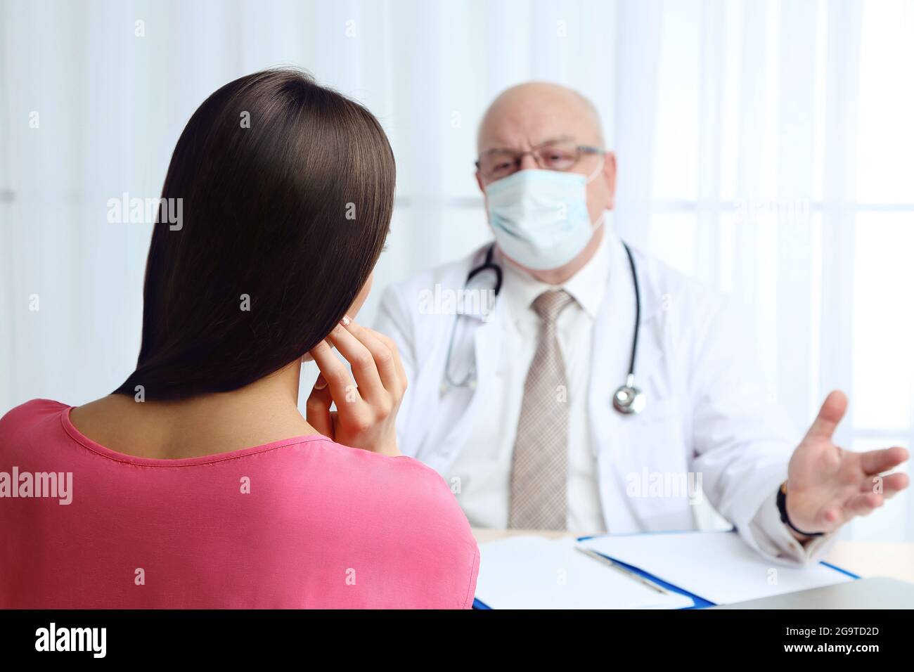 Professional doctor receiving patient in his office on white curtain ...