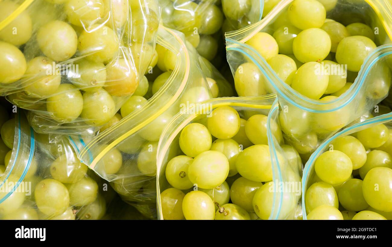 Green-skinned large table grapes in plastic bags at the Farmer's market ...
