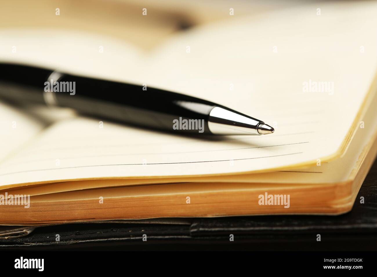 Writing pen on notebook background Stock Photo - Alamy