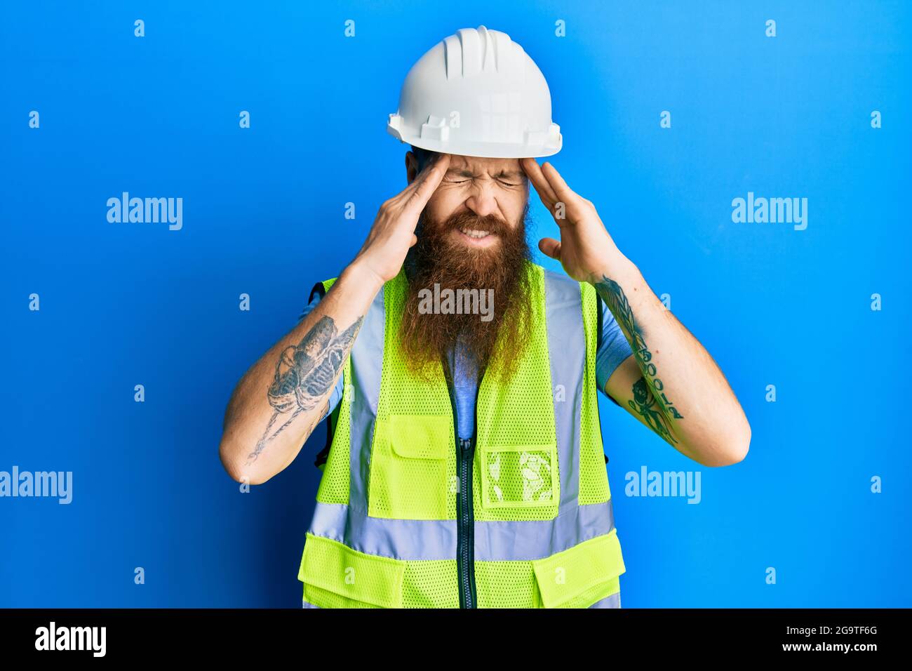 Redhead man with long beard wearing safety helmet and reflective jacket ...