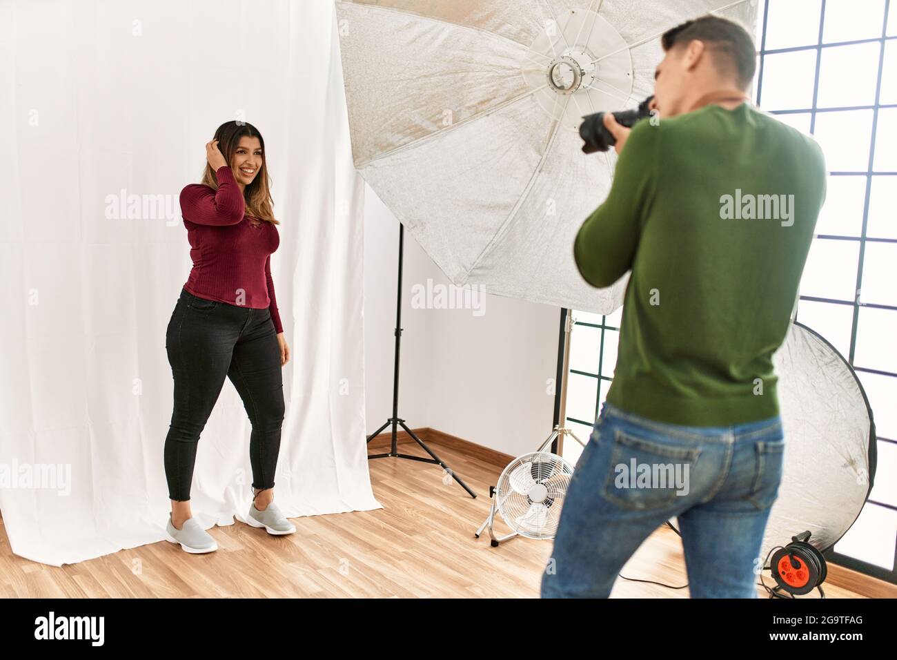 Beautiful model posing for professional photographer at studio Stock ...