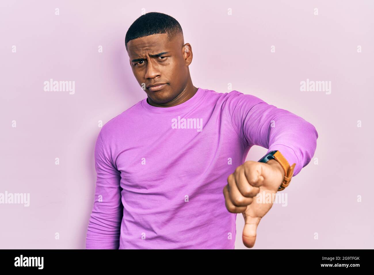 Young black man wearing casual pink sweater looking unhappy and angry ...