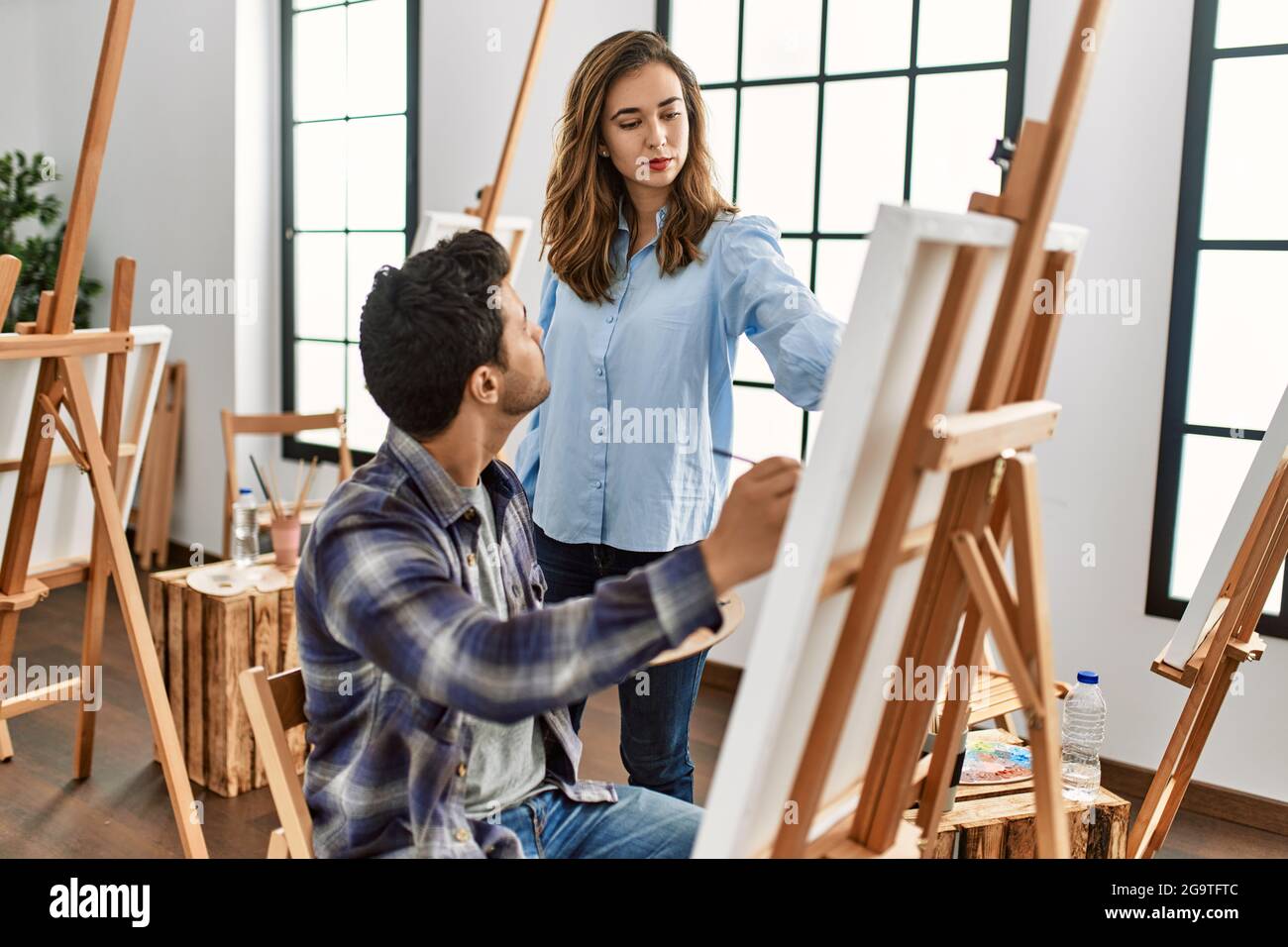 Paint teacher teaching to student at art school Stock Photo - Alamy