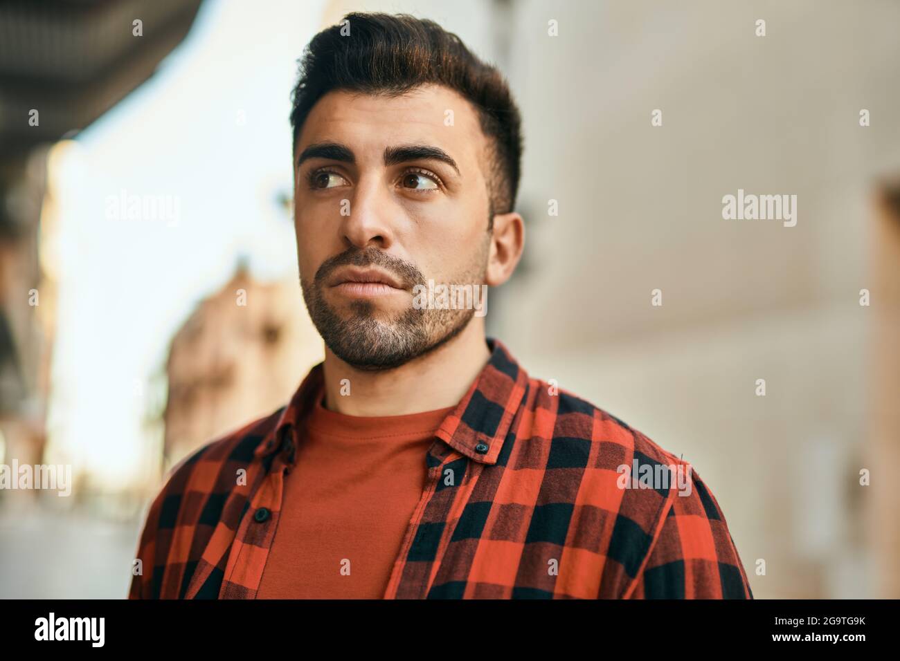 Young hispanic man with serious expression standing at the city Stock ...