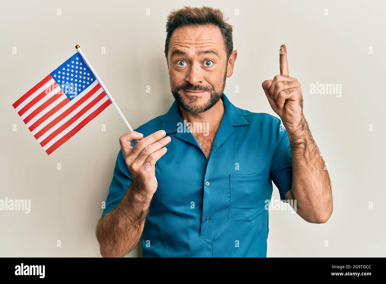 Middle age man holding united states flag smiling with an idea or ...
