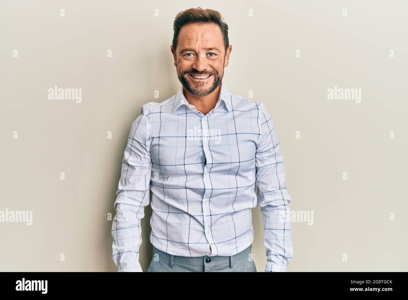 Middle age man wearing business clothes looking positive and happy ...