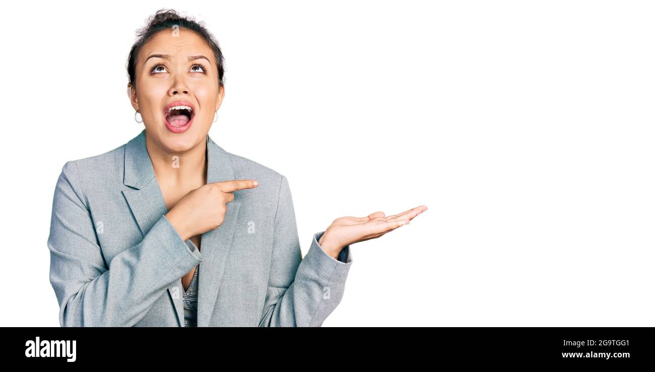 Young hispanic girl pointing open palm with finger angry and mad ...