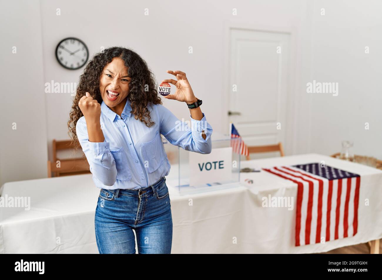 Beautiful hispanic woman standing by at political campaign by voting ...