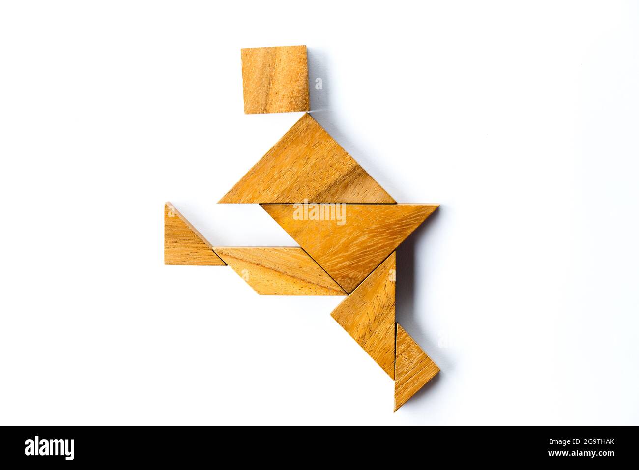 Wood tangram puzzle in man dancing or kicking shape on white background ...