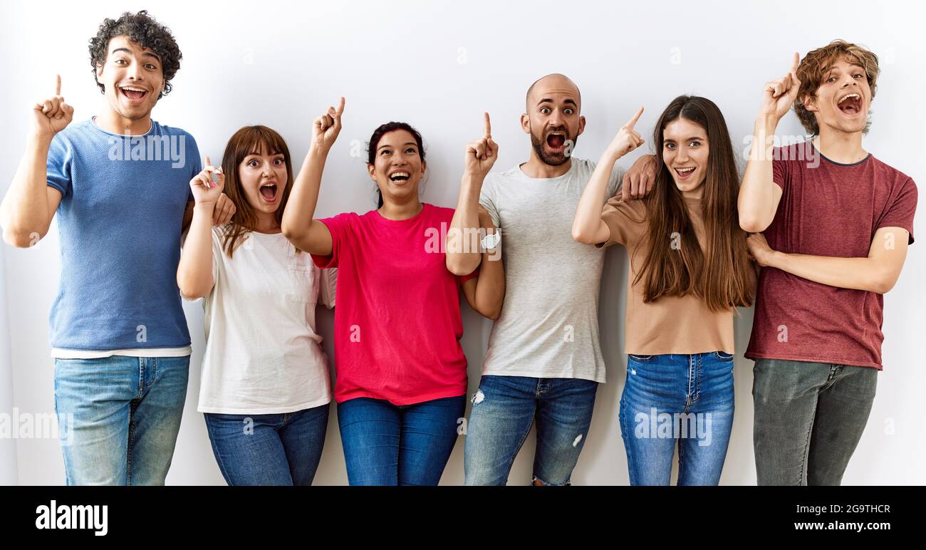 Group of young friends standing together over isolated background ...