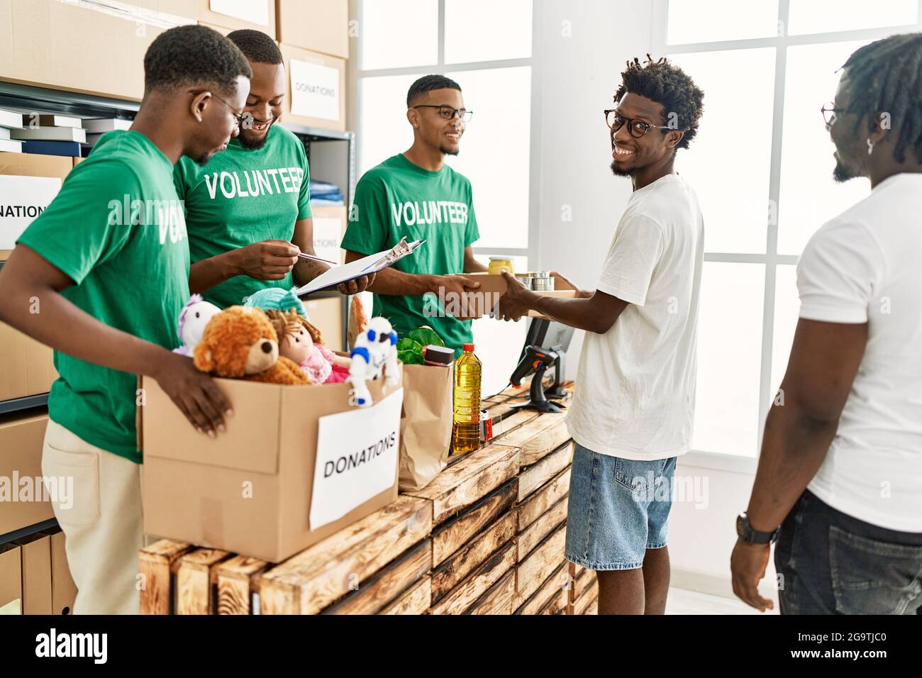 Group of young african american volunteers helping people at charity ...