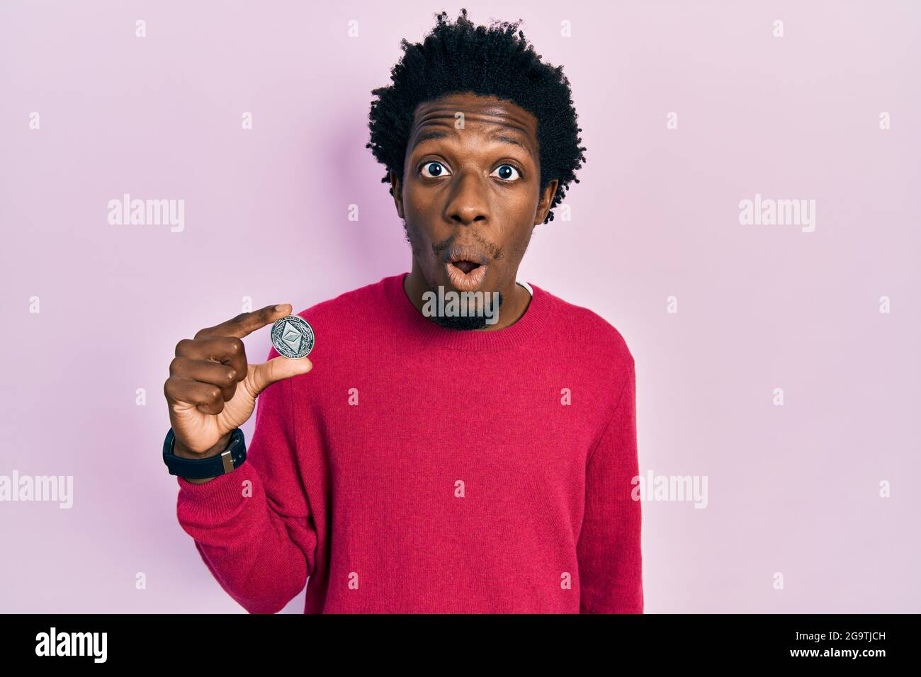 Young african american man holding virtual currency ethereum coin ...