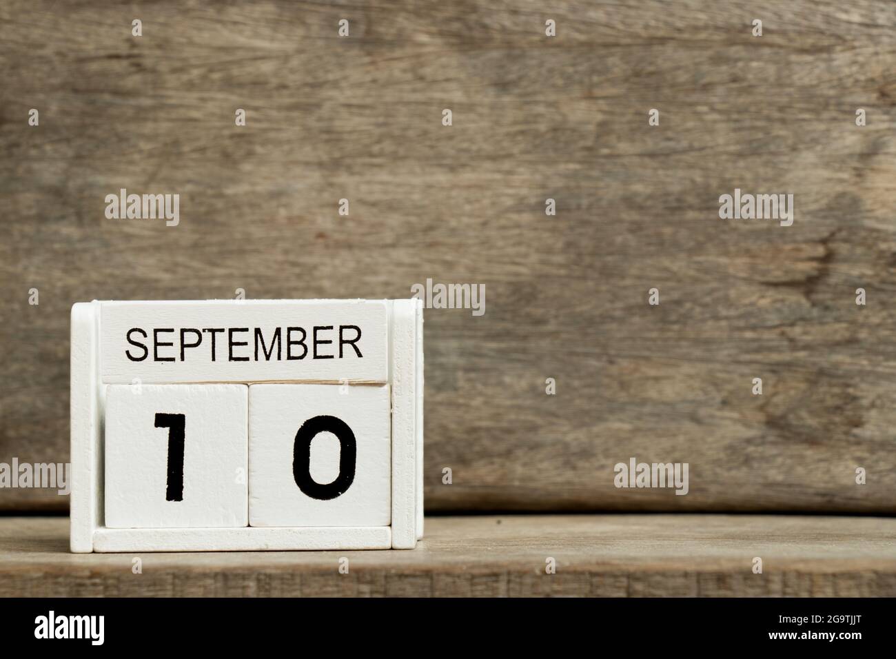 White block calendar present date 10 and month September on wood ...