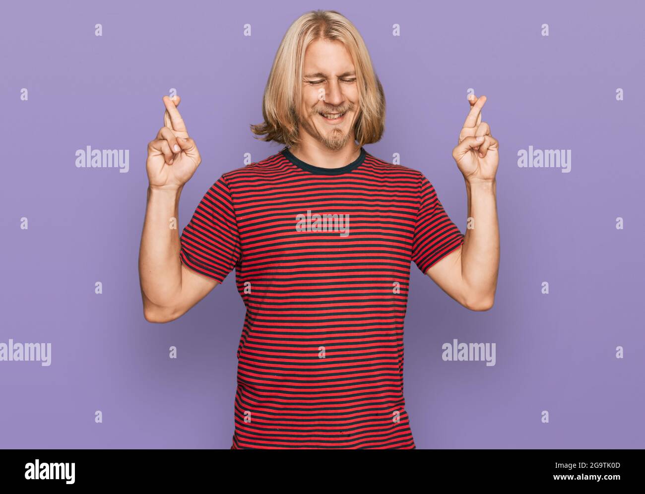 Caucasian man with blond long hair wearing casual striped t shirt ...