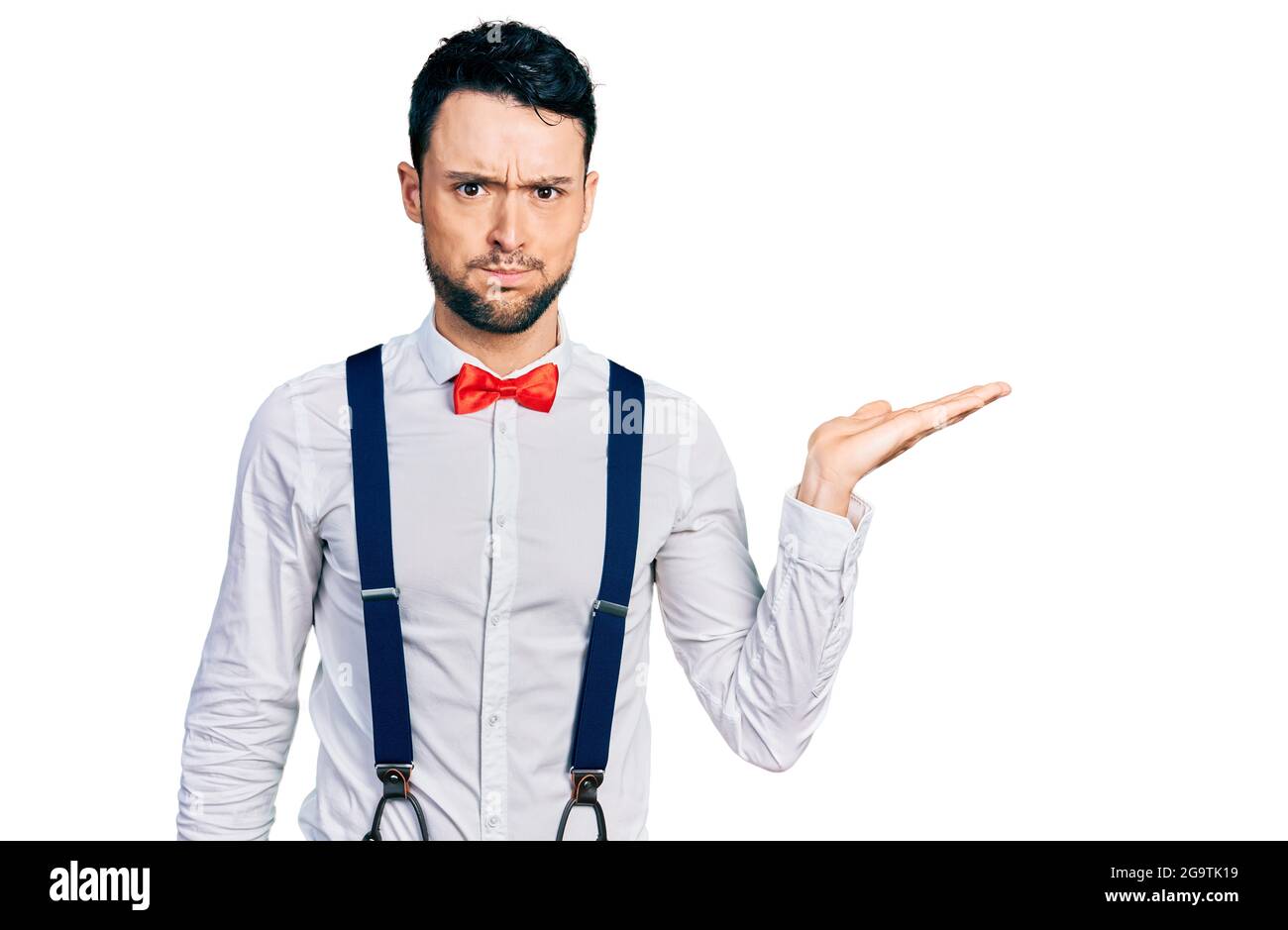 Hispanic man with beard presenting with open palm puffing cheeks with ...