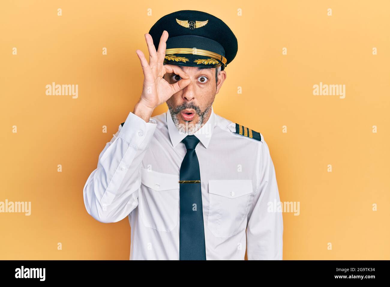 Handsome middle age man with grey hair wearing airplane pilot uniform ...