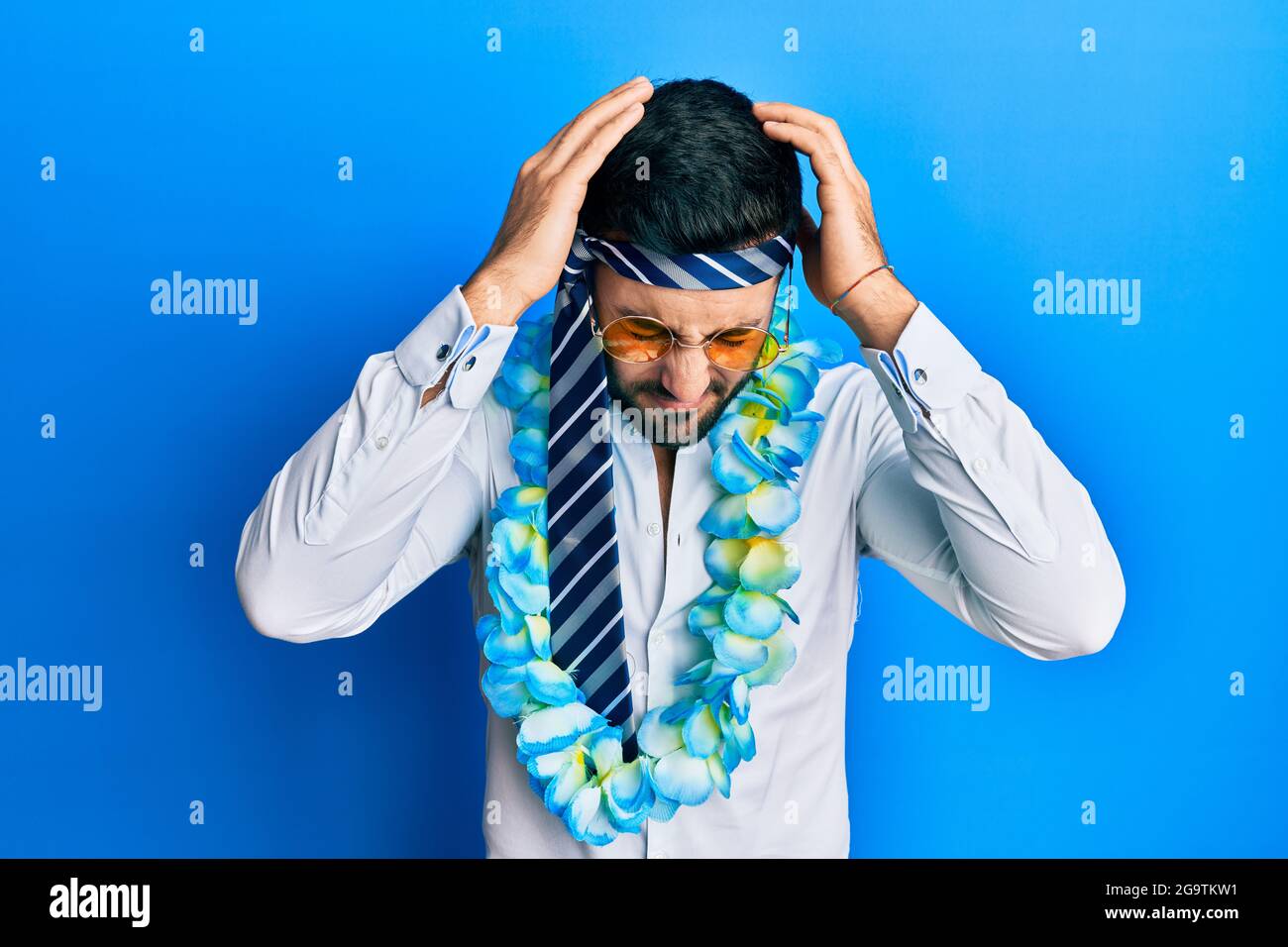 Young hispanic businessman wearing party funny style with tie on head ...