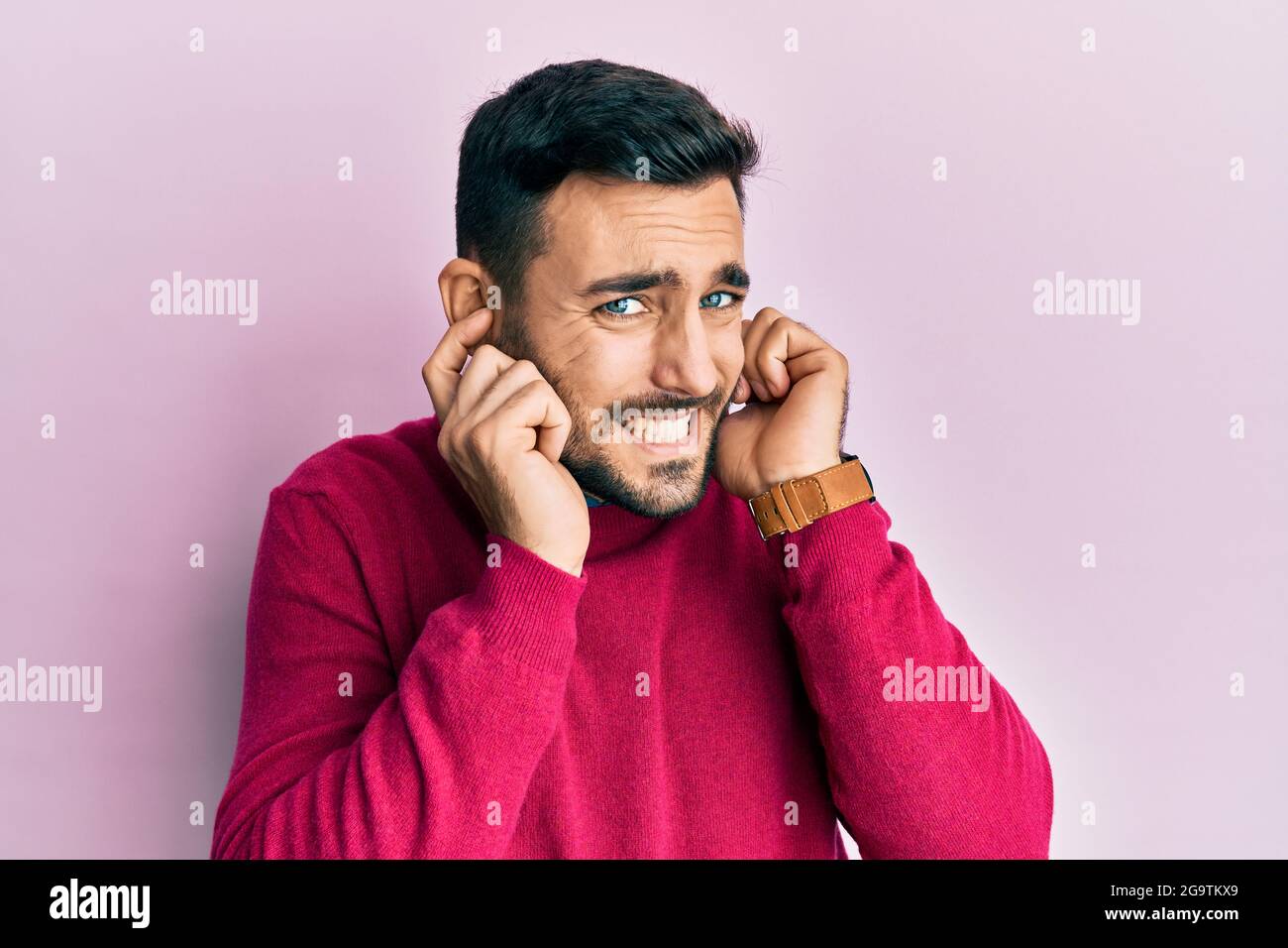 Young hispanic man wearing casual clothes covering ears with fingers ...