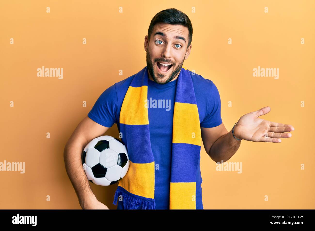 Young hispanic man football hooligan soccer ball celebrating ...