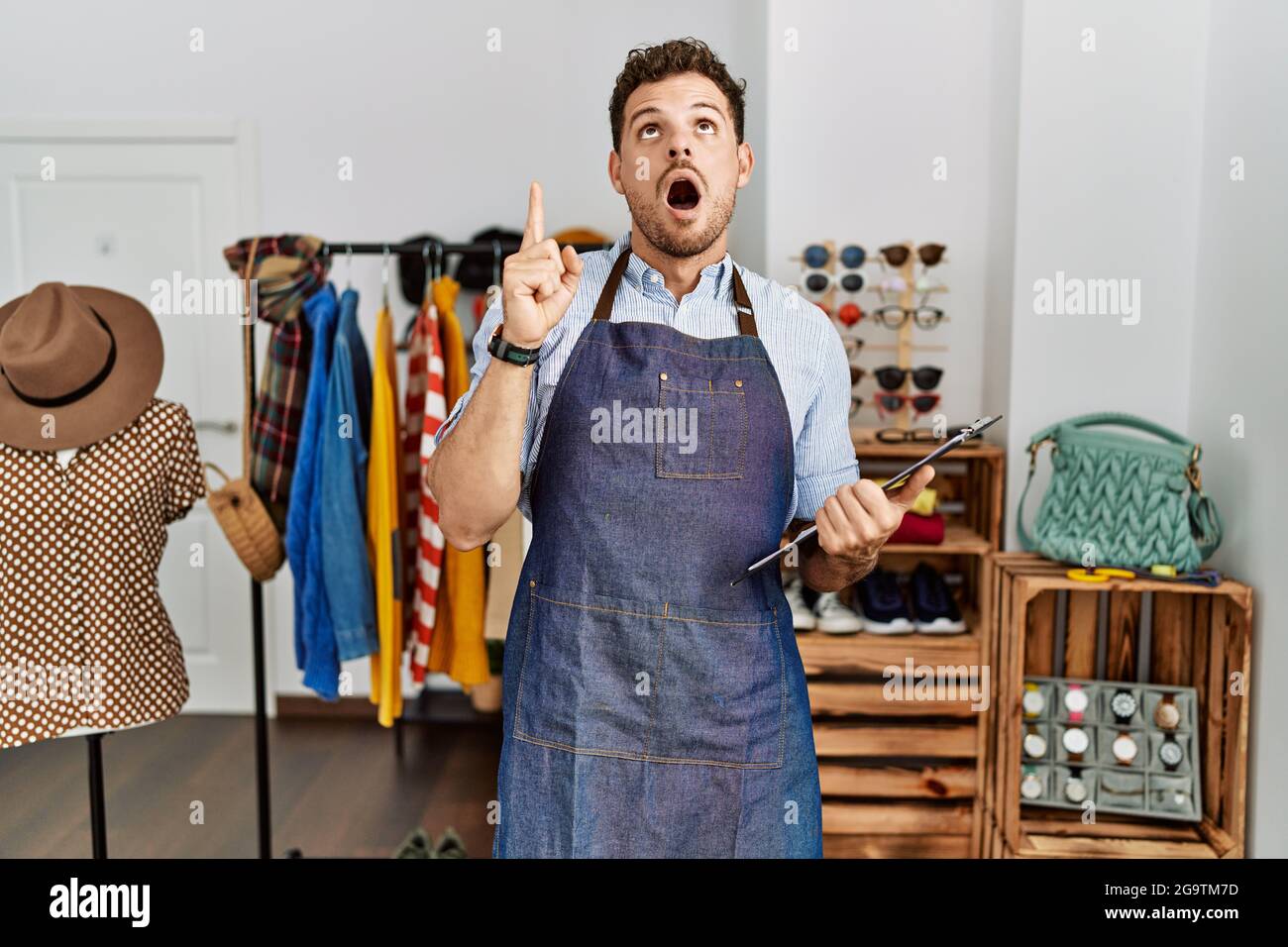Handsome young man working as manager at retail boutique amazed and ...