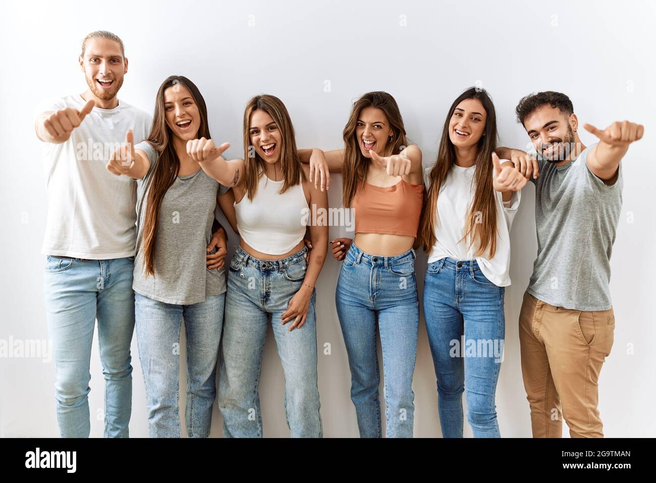 Group of young friends standing together over isolated background ...